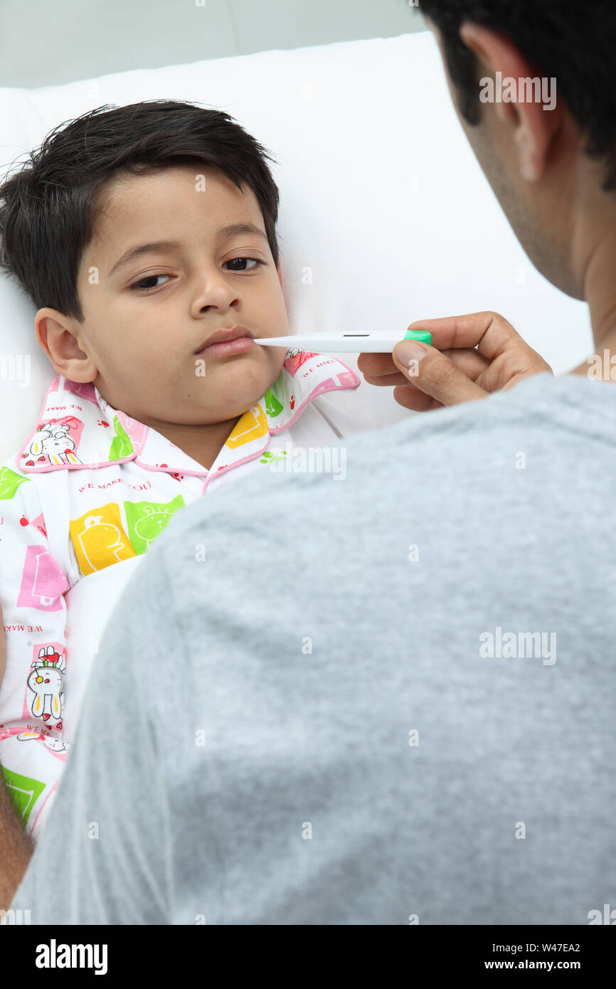Indian man checking his son temperature Stock Photo - Alamy