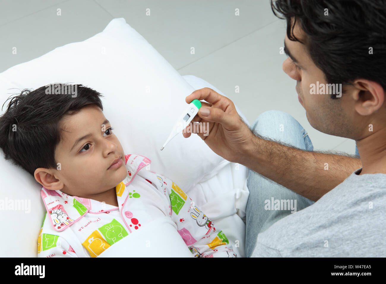 Man checking his son temperature Stock Photo - Alamy
