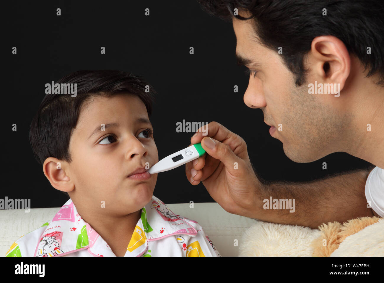 Man checking his son,s temperature Stock Photo - Alamy