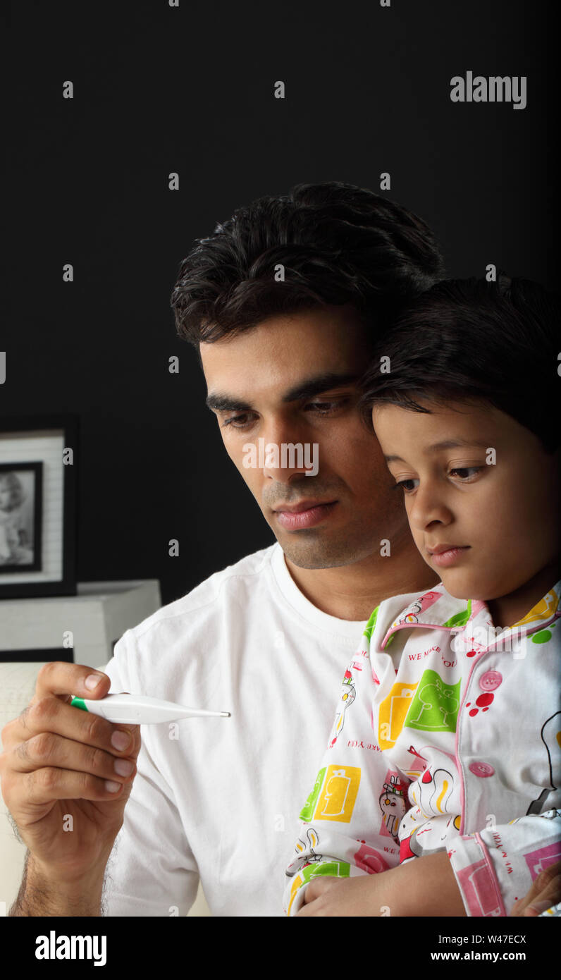 Man checking his son,s temperature Stock Photo - Alamy