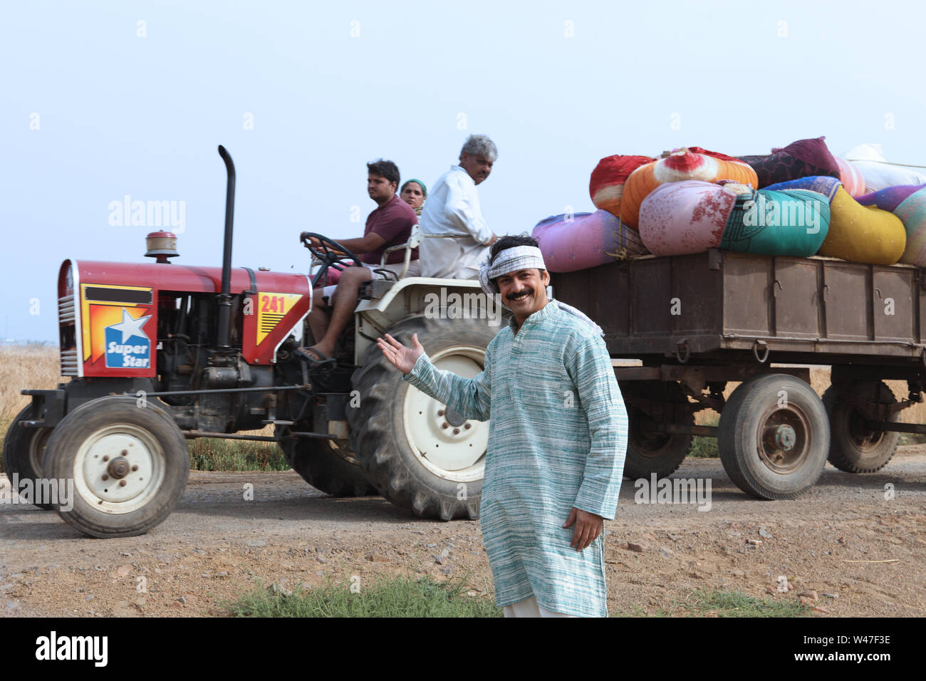 Farmer pointing towards tractor Stock Photo - Alamy