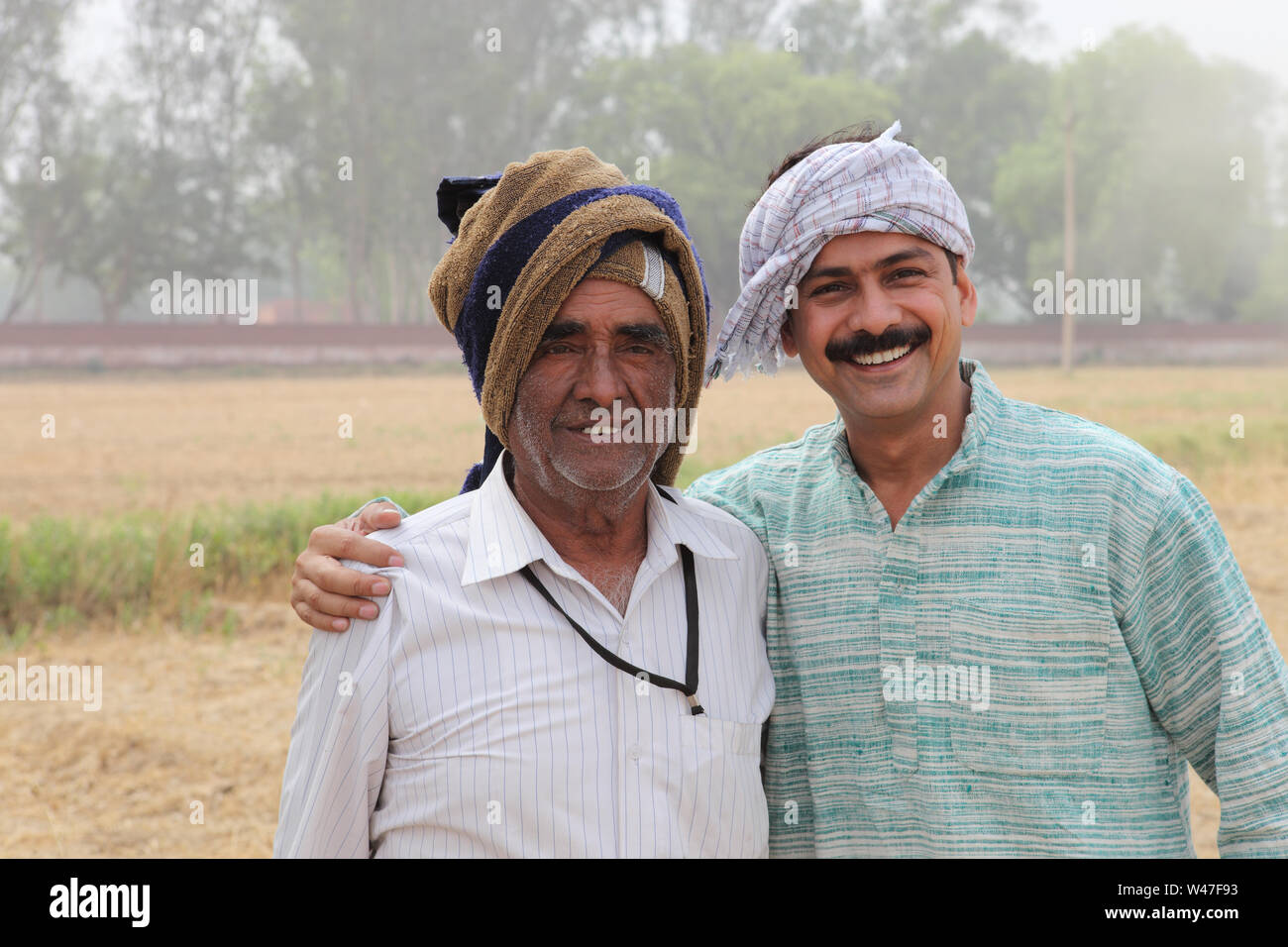 Portrait of a farmer smiling with his father Stock Photo - Alamy