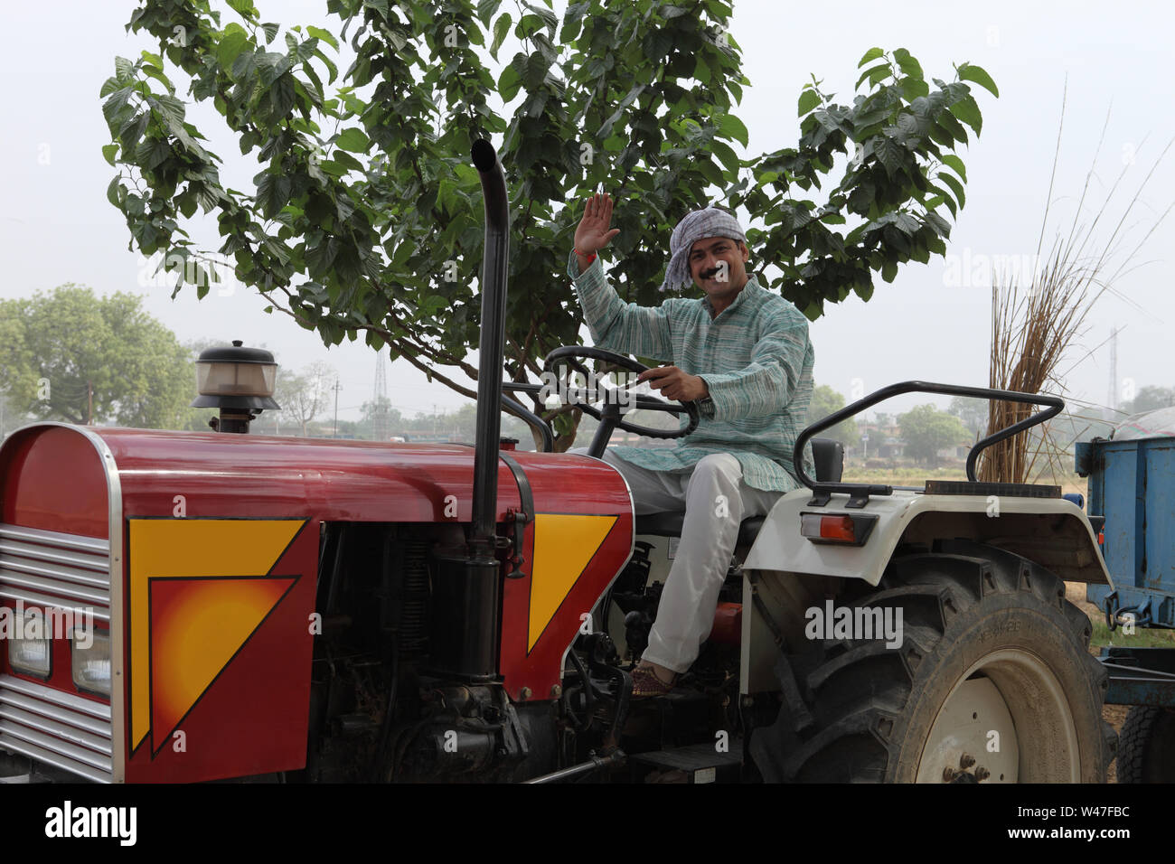 Farmer driving a tractor Stock Photo - Alamy