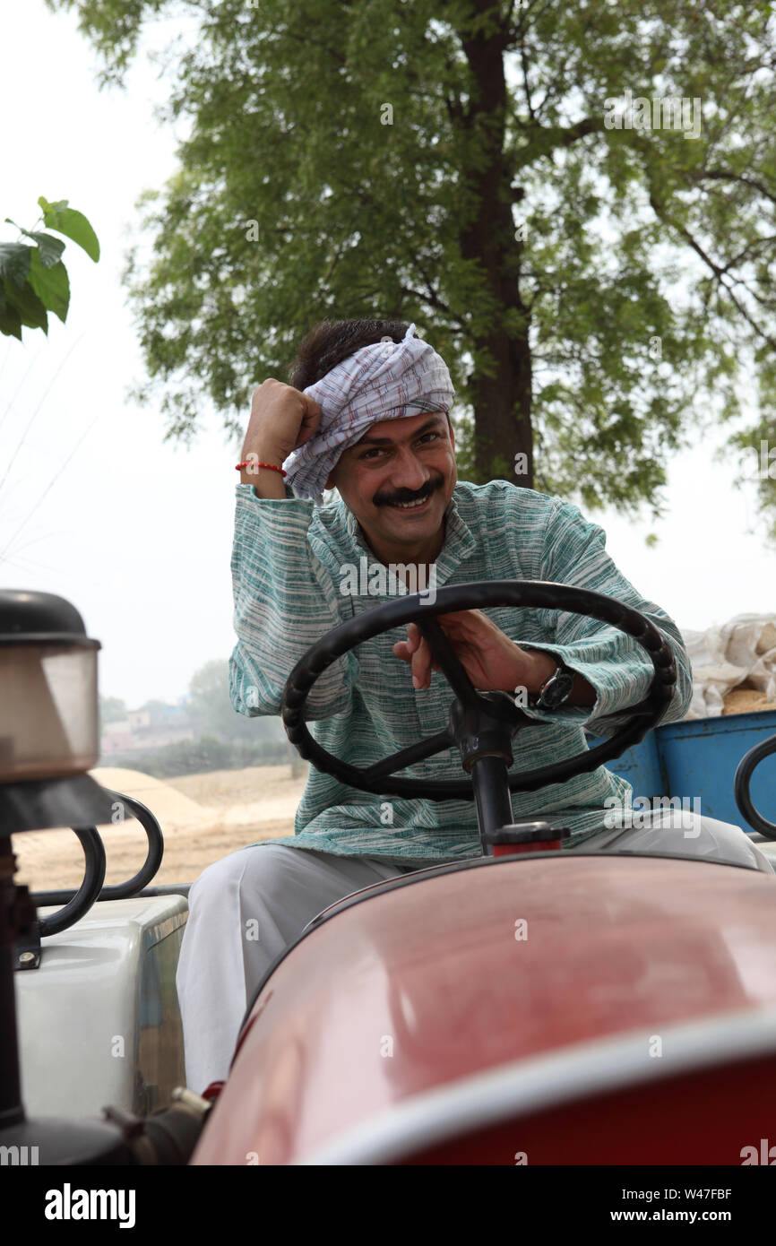 Portrait of an Indian farmer smiling on tractor Stock Photo - Alamy