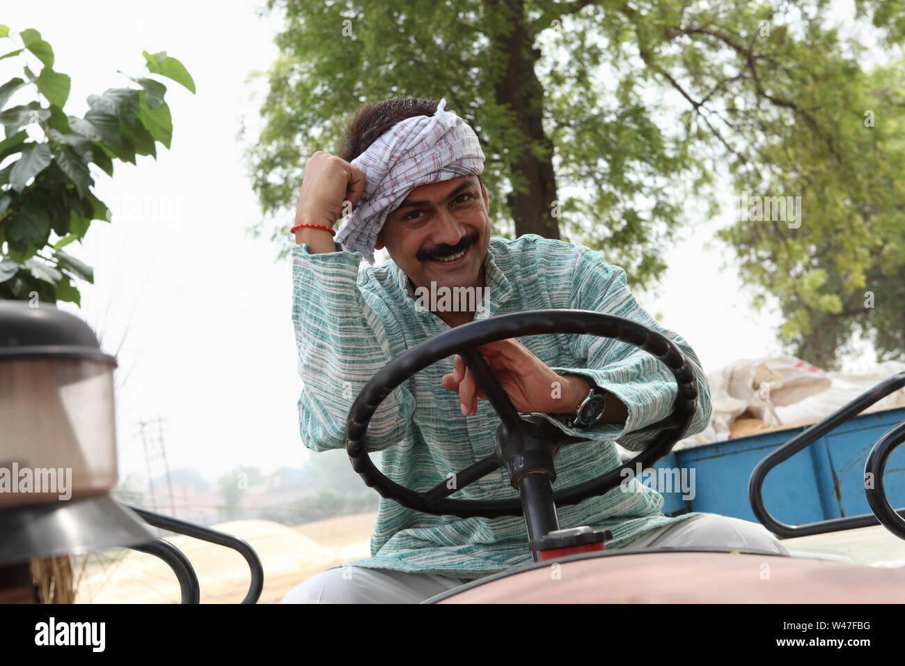 Portrait of a farmer smiling on tractor Stock Photo - Alamy