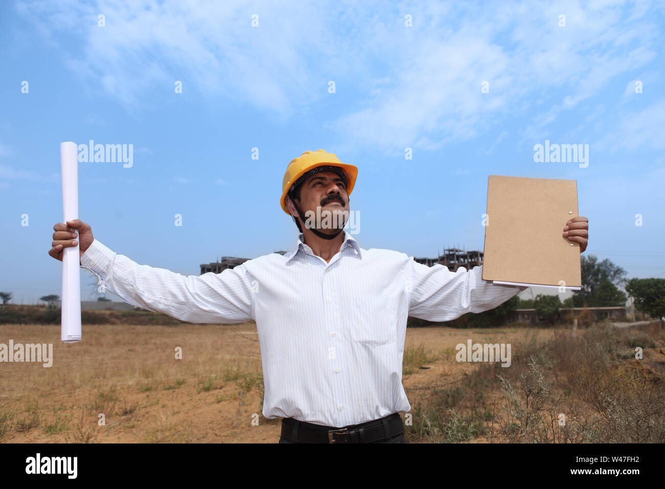 Architect standing with arm outstretched at a construction site Stock ...