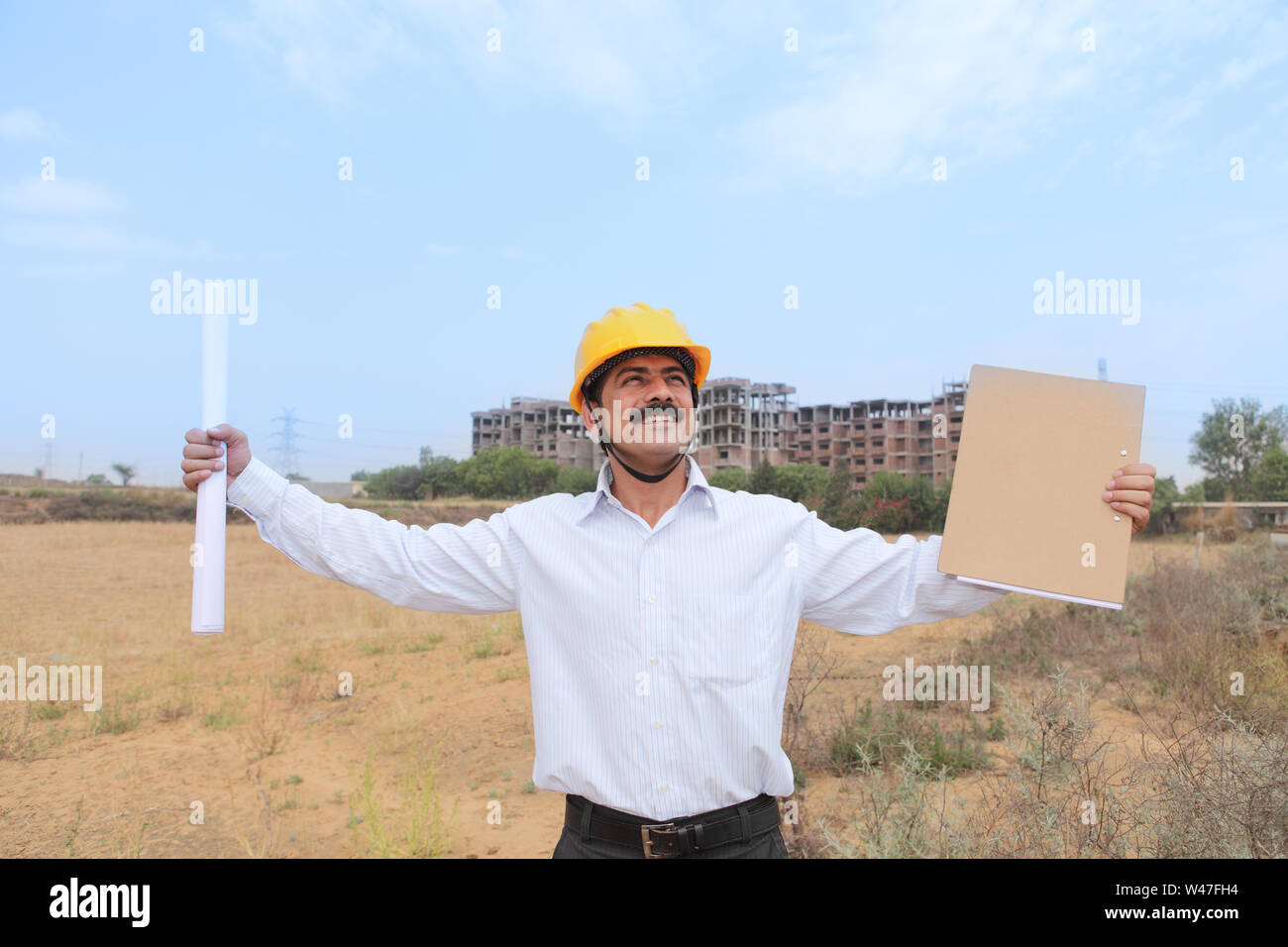 Architect standing with arm outstretched at a construction site Stock ...