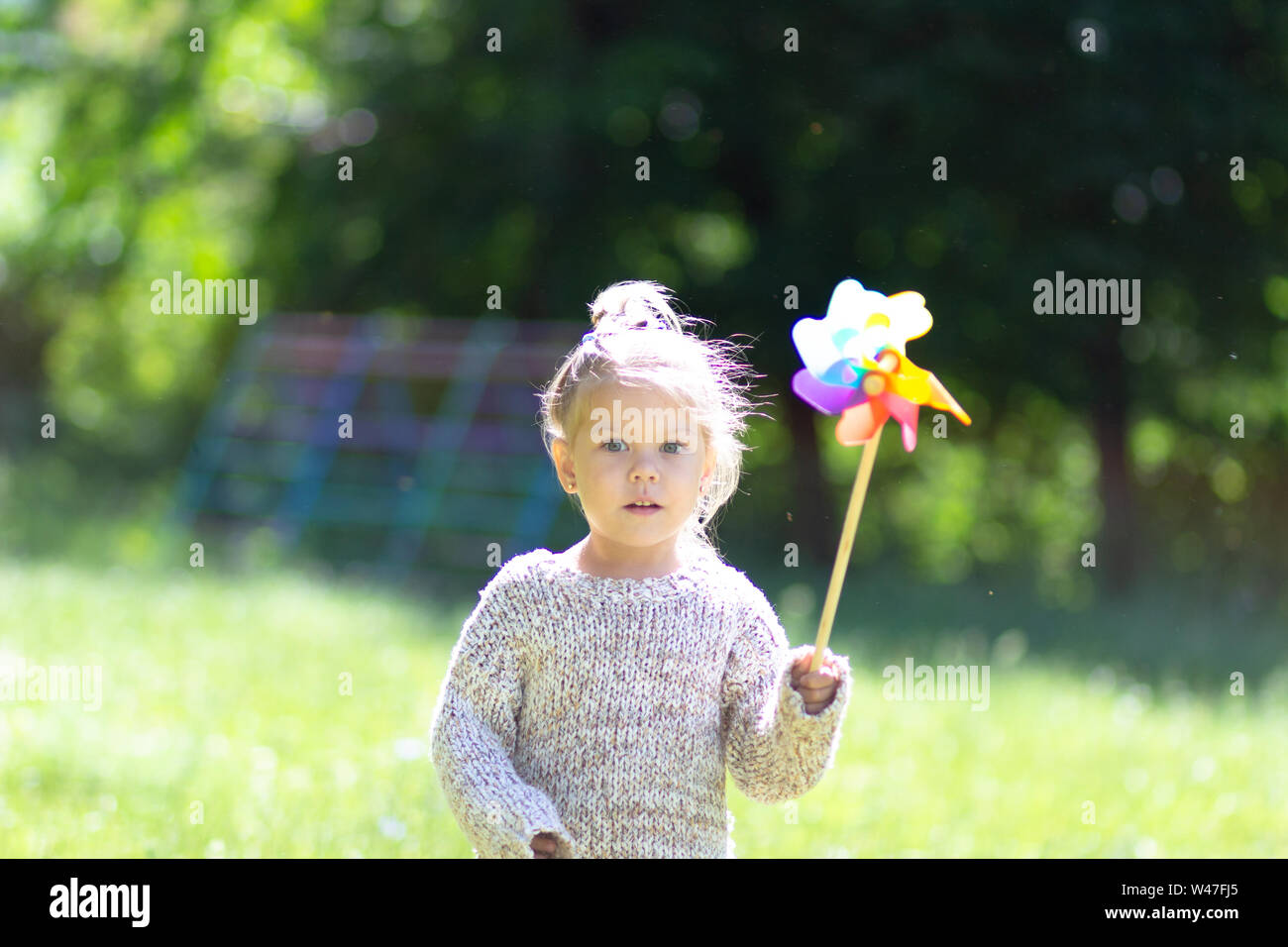 Child with Pinwheel in the summer park looking at camera Stock Photo ...