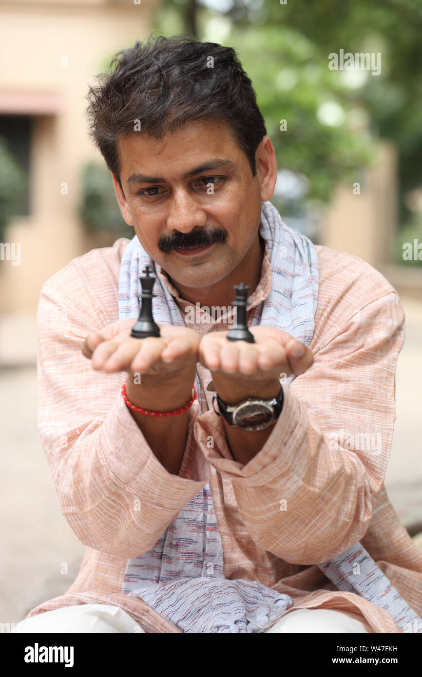 Rural man looking chess piece Stock Photo - Alamy