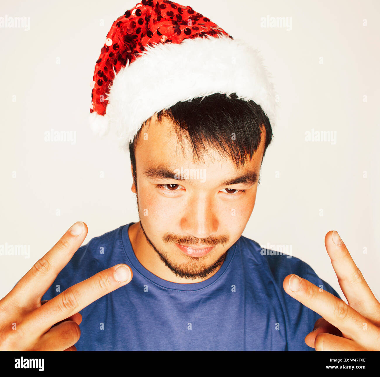 funy exotical asian Santa claus in new years red hat smiling on white ...