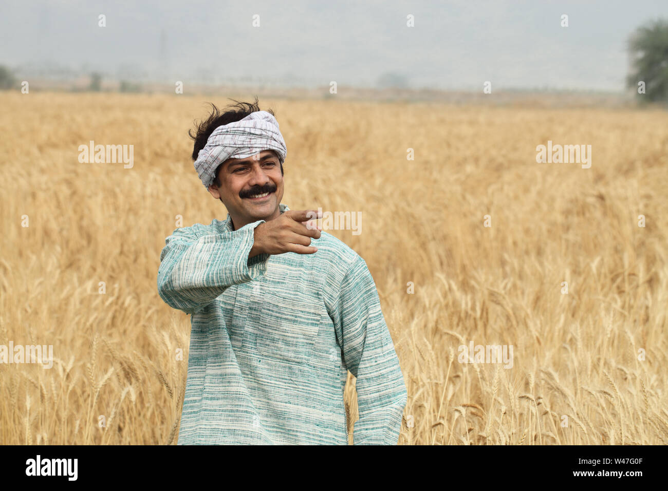 Farmer pointing and standing in a field Stock Photo - Alamy
