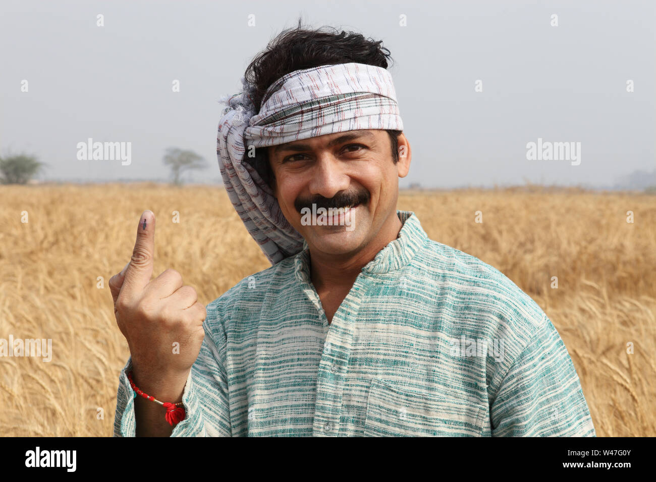 Indian farmer pointing upward in a field Stock Photo - Alamy