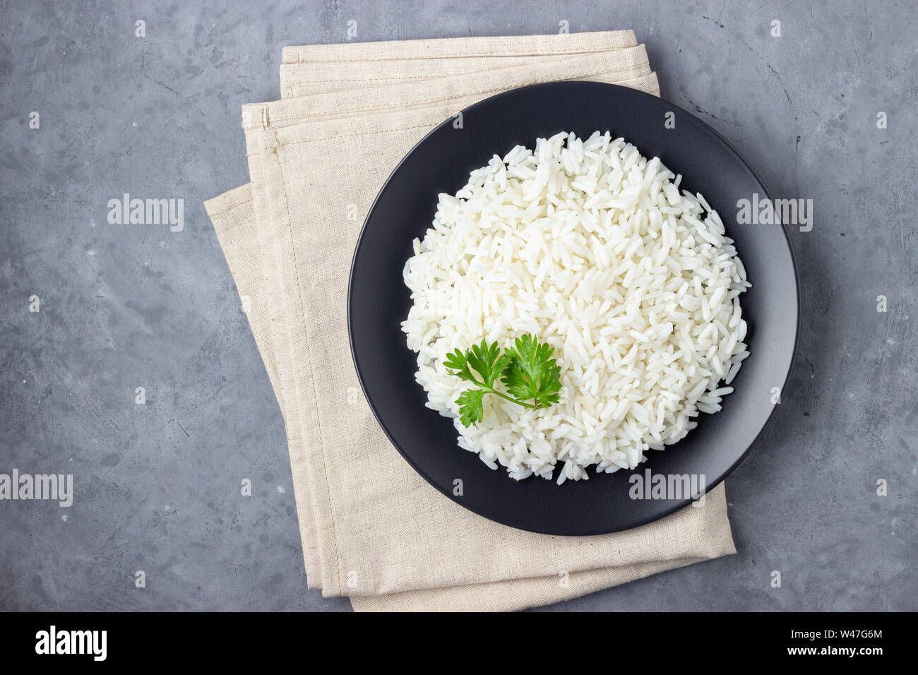Steamed rice on black plate. Gray stone background. Top view Stock ...
