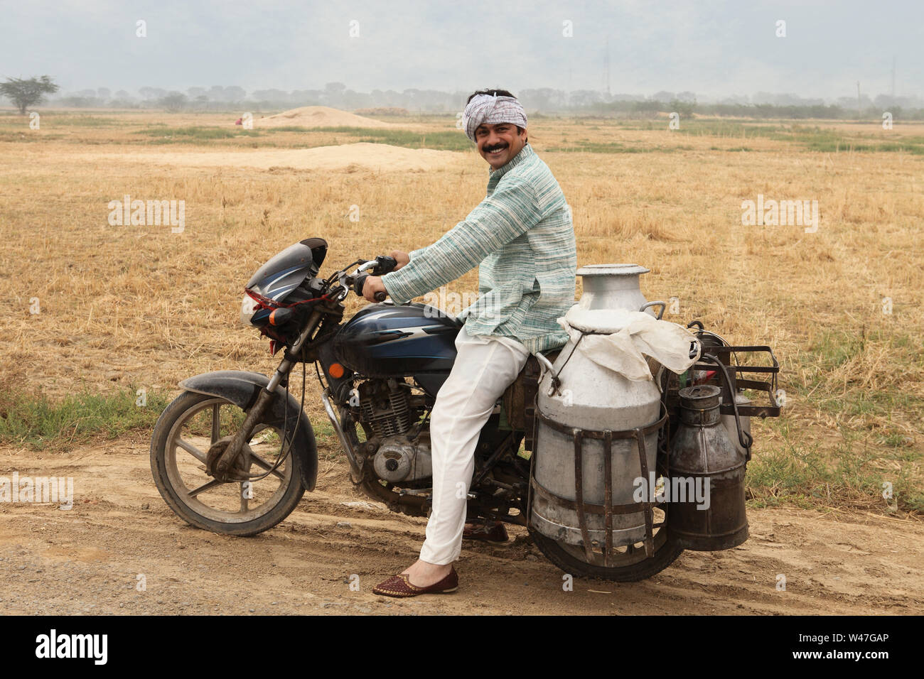 Milkman delivering milk on a motorcycle Stock Photo - Alamy