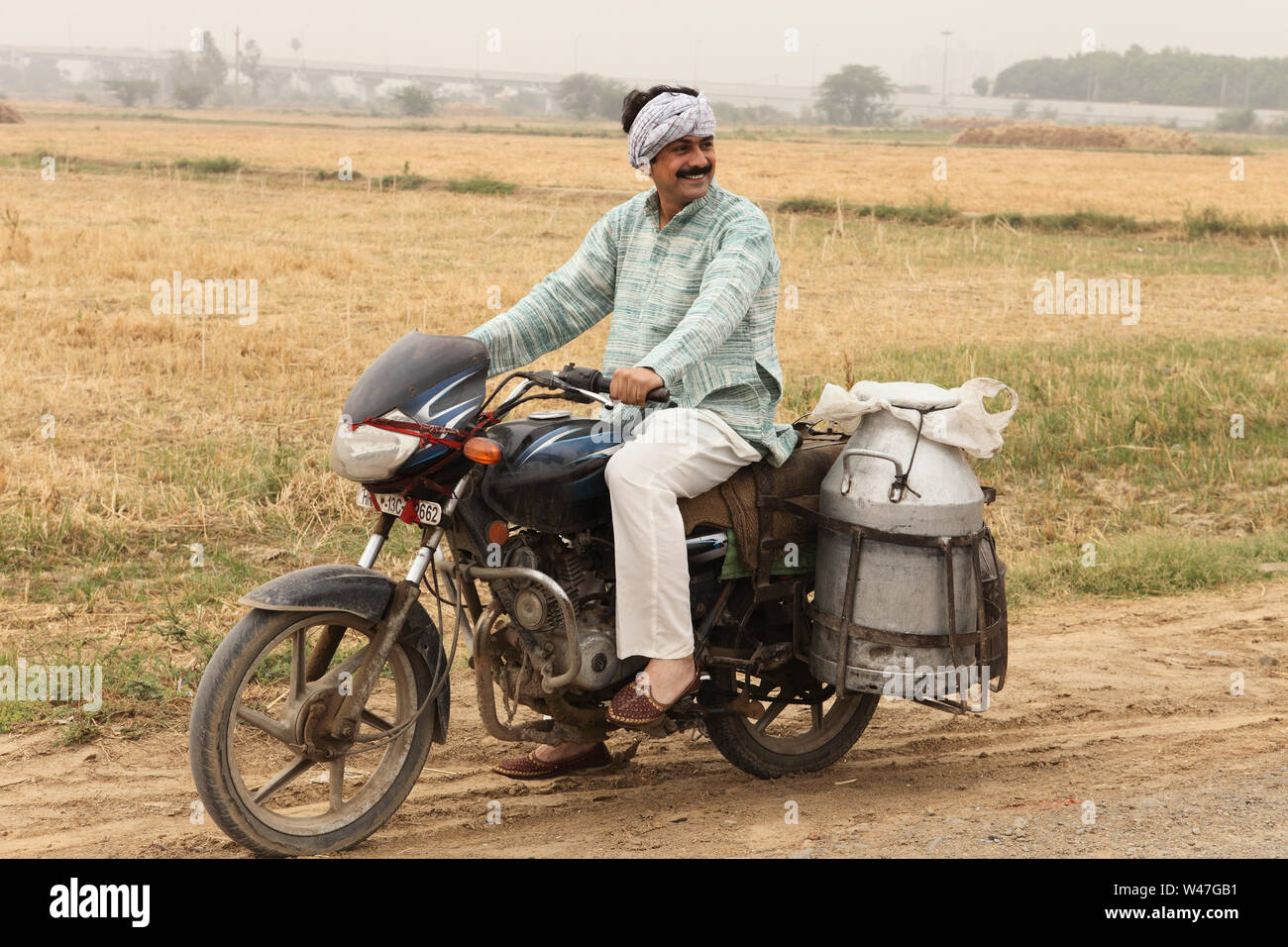 Milkman delivering milk on a motorcycle Stock Photo - Alamy