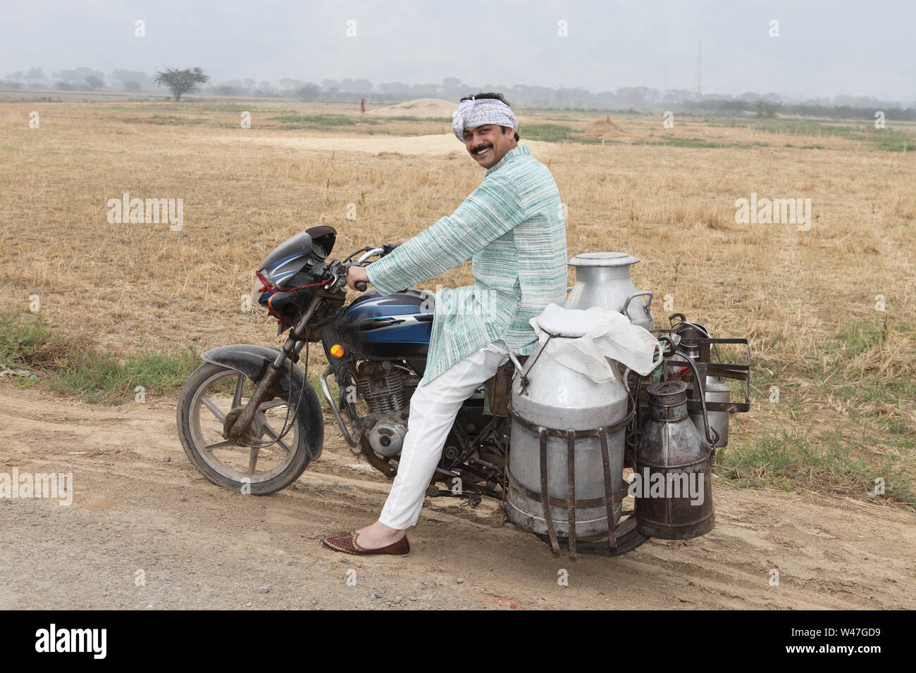 Milkman delivering milk on a motorcycle Stock Photo - Alamy