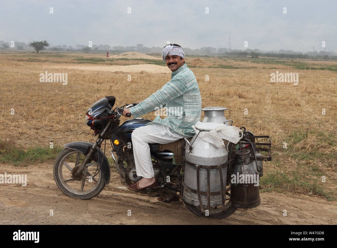 Milkman delivering milk on a motorcycle Stock Photo - Alamy
