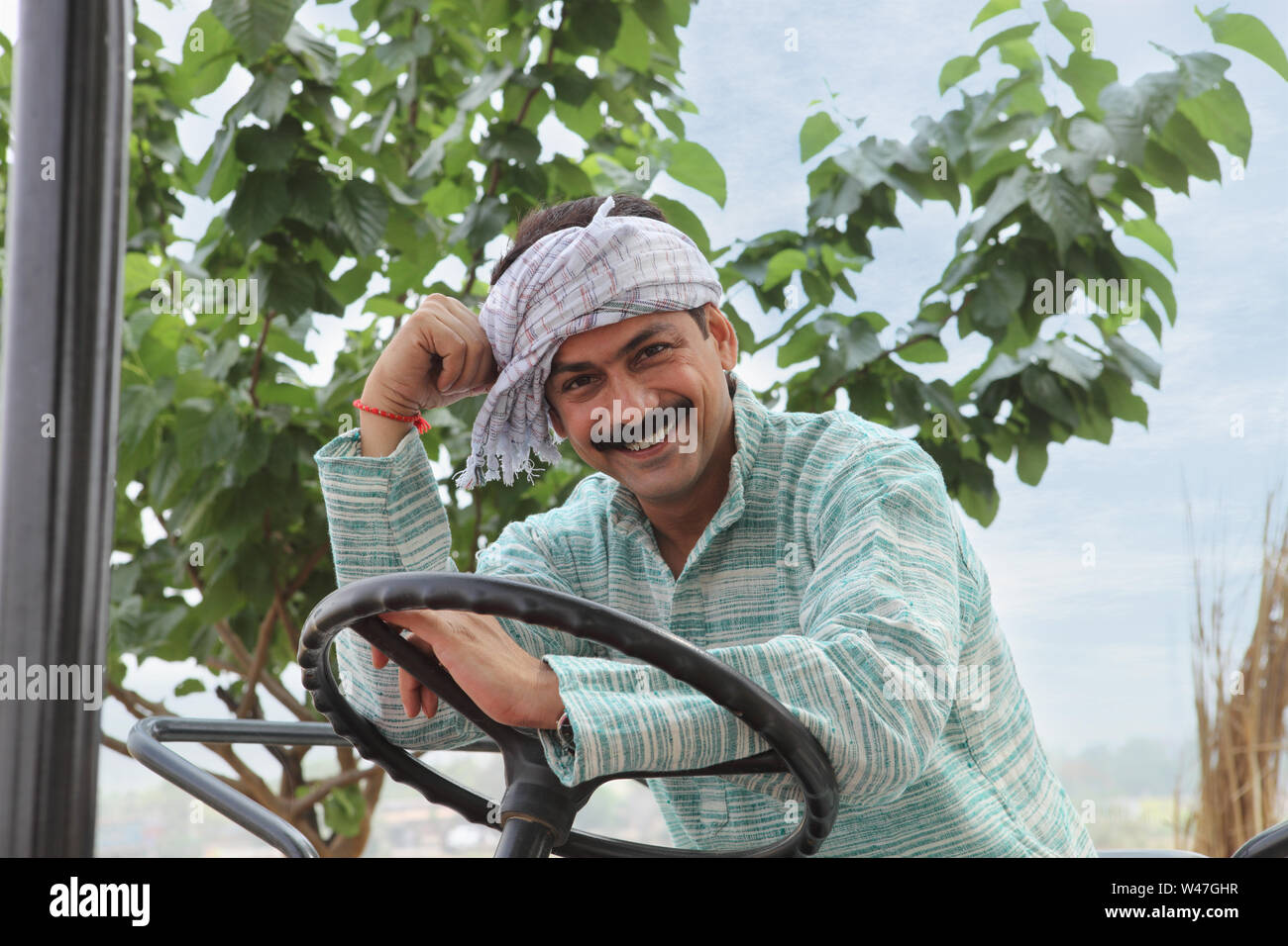 Portrait of an Indian farmer smiling on tractor Stock Photo - Alamy