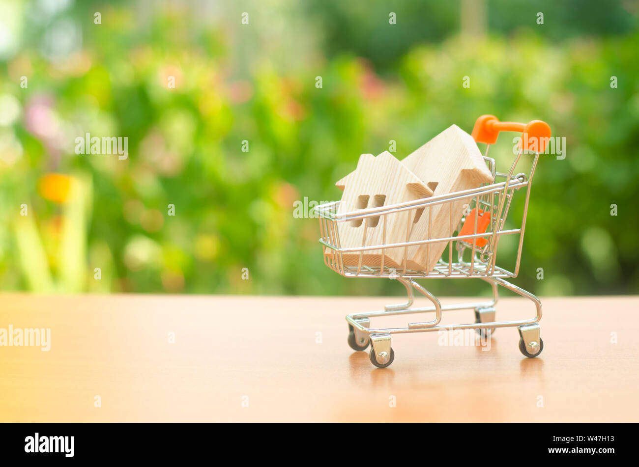 Two wooden houses in a trading cart on nature background. The concept ...