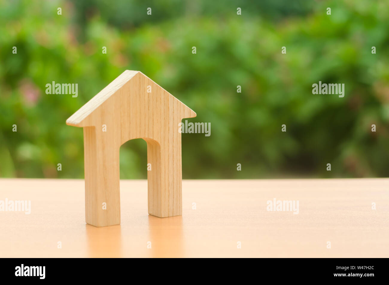 Wooden figure of a house with a large doorway on nature background ...