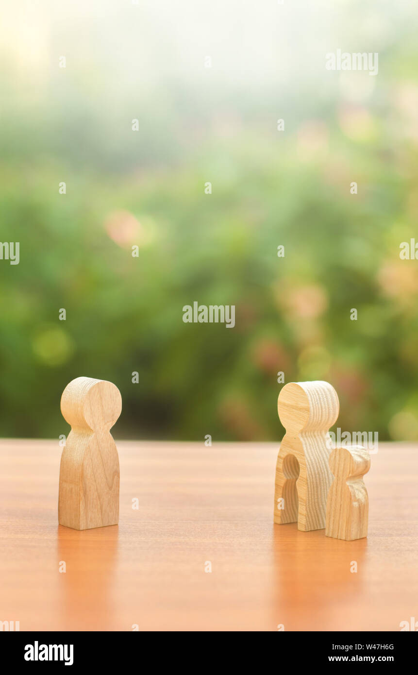 Wooden figures of a mother with a child stands apart from the father ...