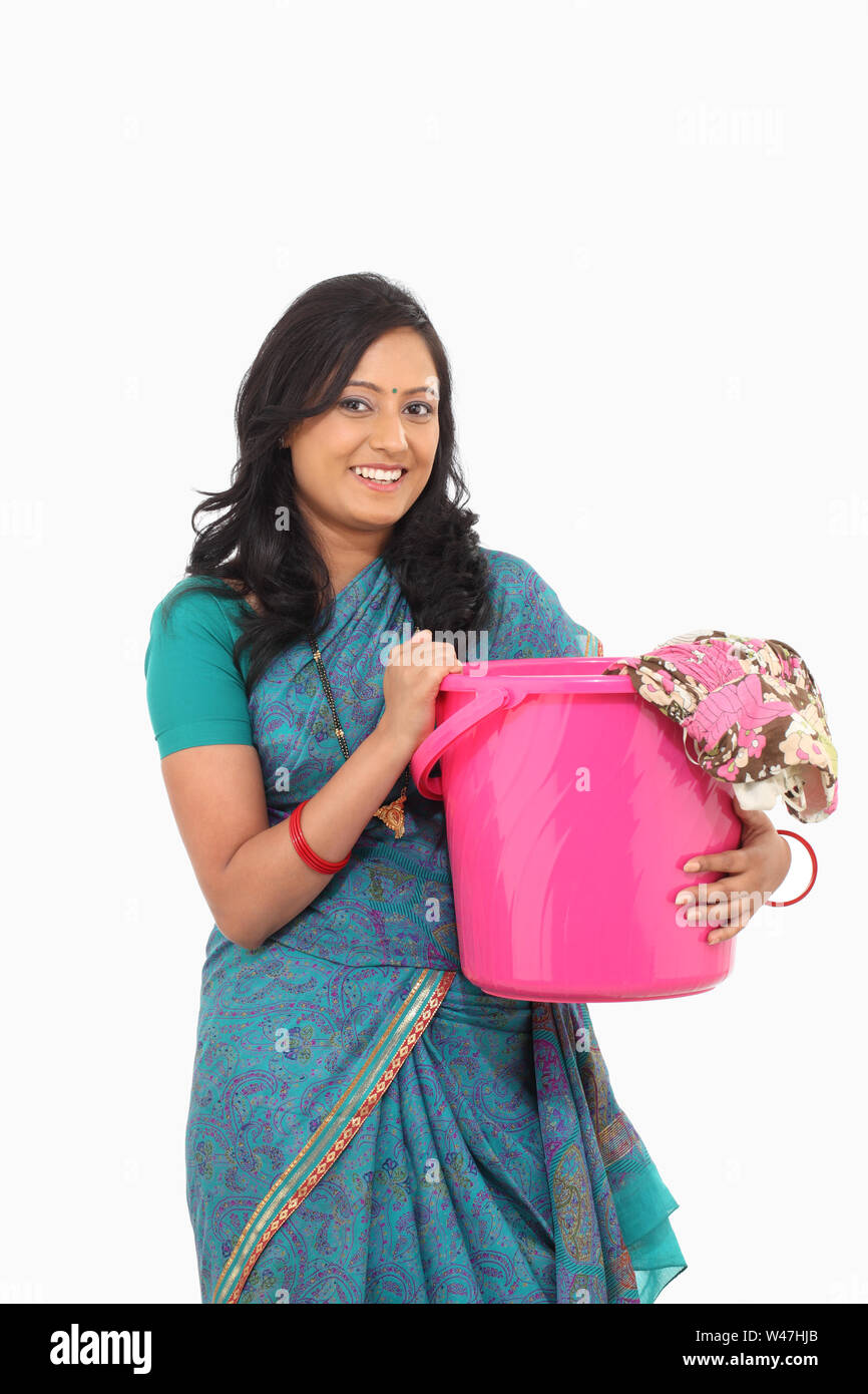 Woman carrying bucket and smiling Stock Photo - Alamy