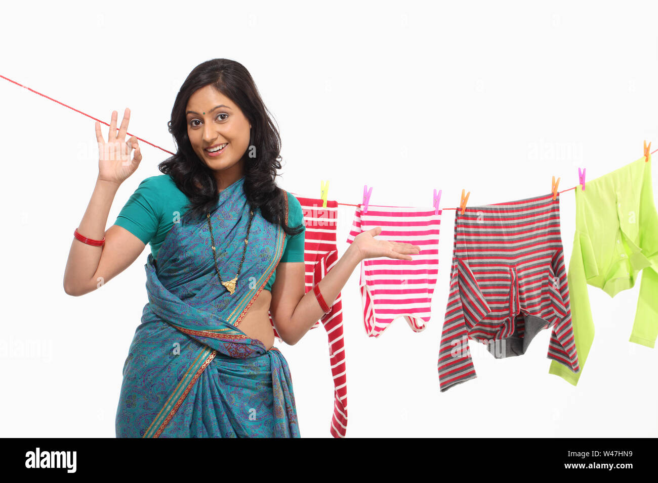 Woman drying clothes and showing ok sign Stock Photo - Alamy