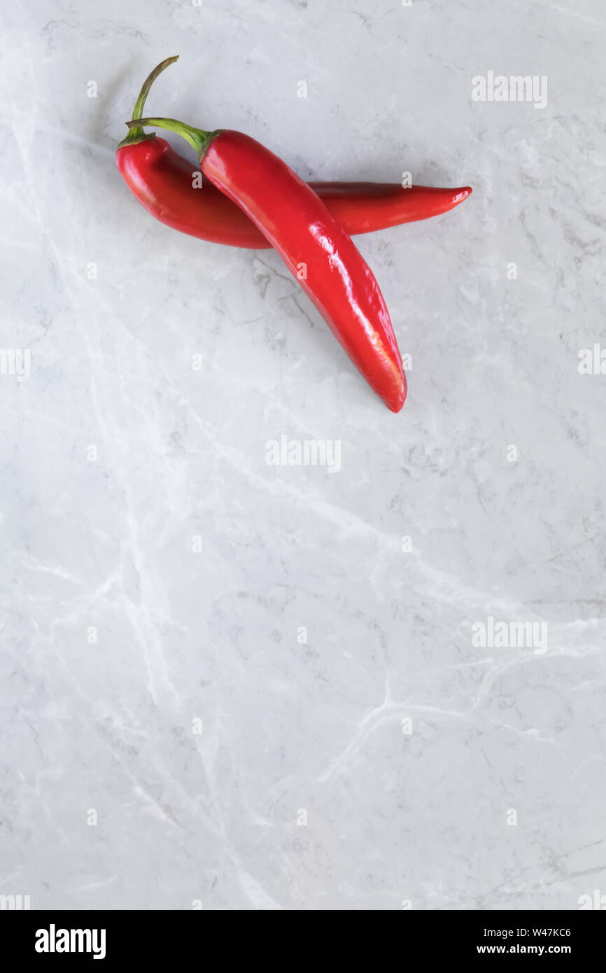 Two hot chili peppers on grey marble background, crescent shaped. use ...