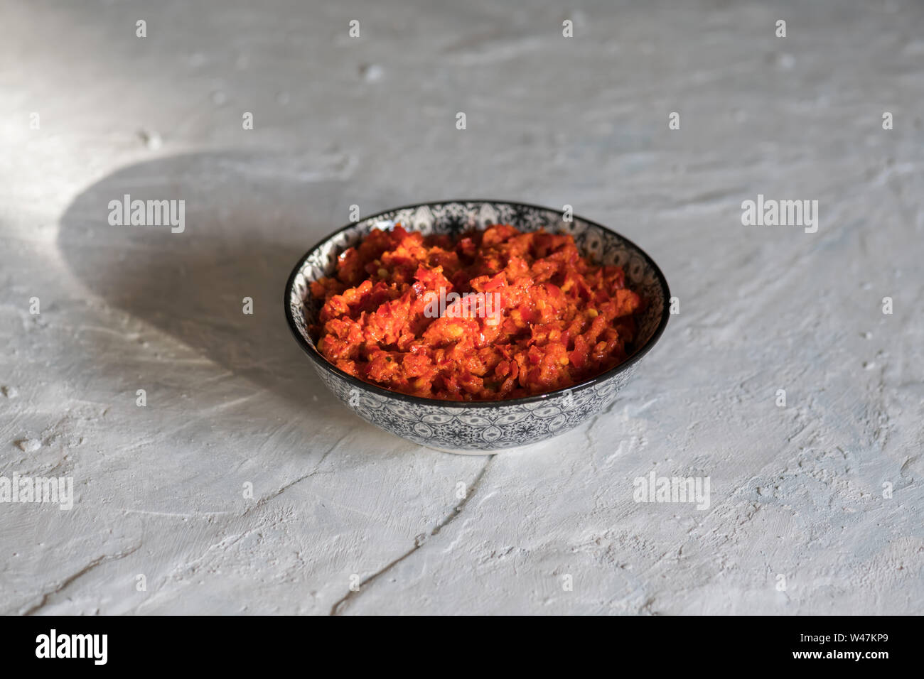 Traditional Maghrebi hot chili pepper sauce harissa on a grey ...