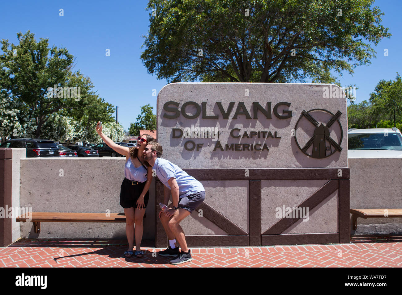 two visitors to the town of Solvang California stop to take a selfie at ...