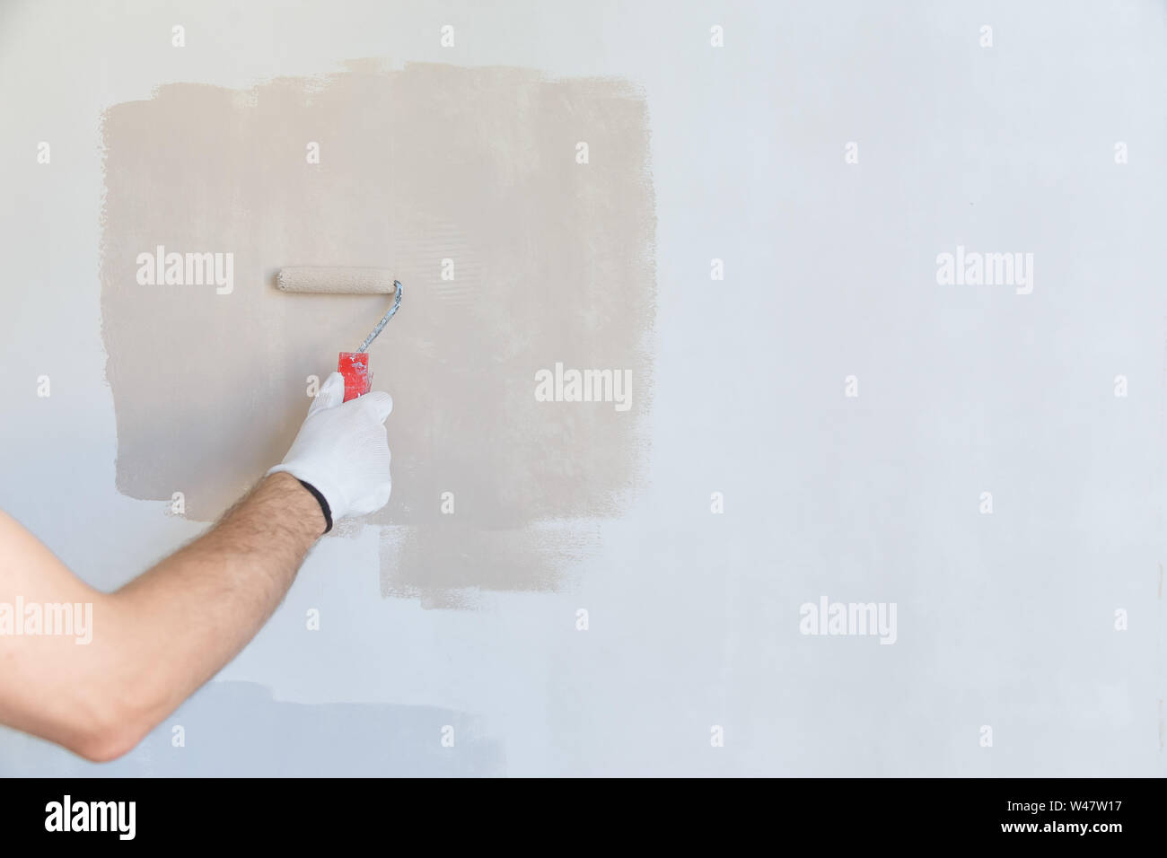 painter hand in white glove painting a wall with paint Stock Photo - Alamy