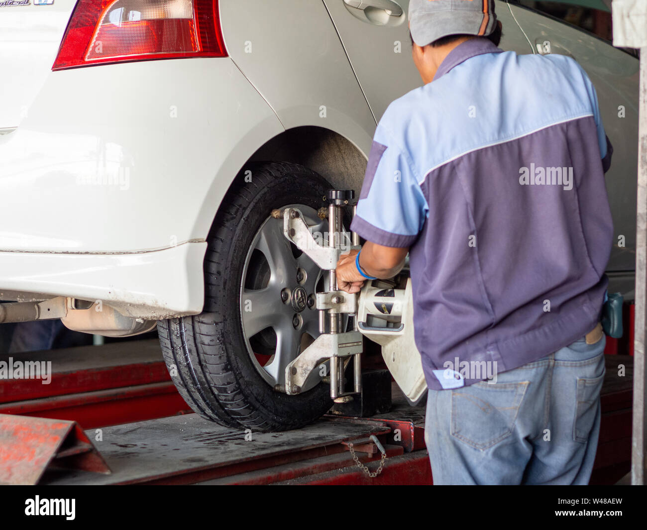 Mechanician changing car wheel in auto repair shop Stock Photo - Alamy
