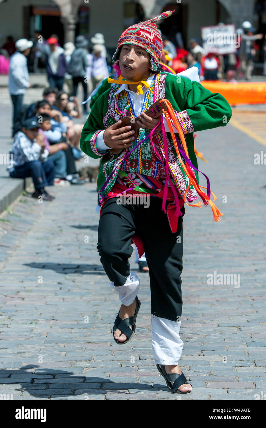 A musician in Peruvian costume with an imitation guitar performs at ...