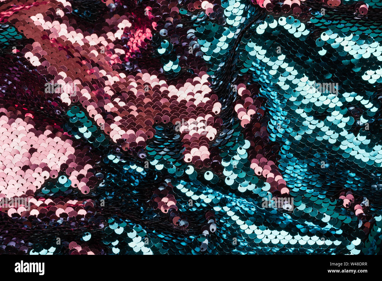 Festive background made of turquoise and pink sequins. Shiny fabric ...