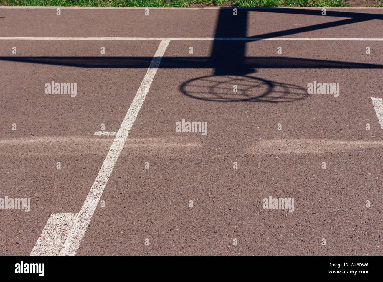 Shadow of a street basketball board with ring and net on the aspahlted ...
