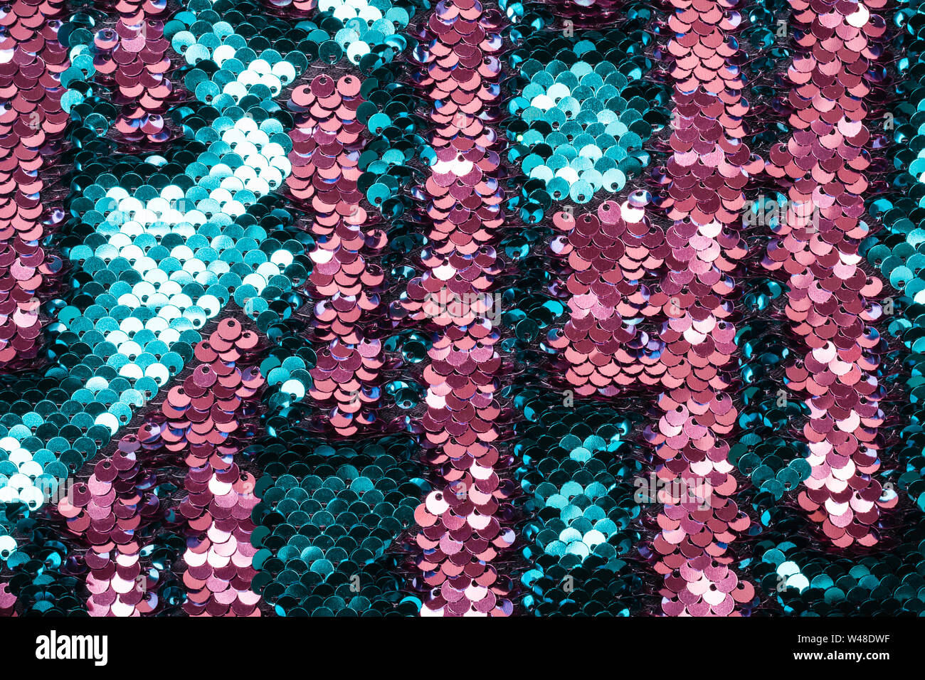 Coral and turquoise iridescent sequins on fabric. Festive trendy ...