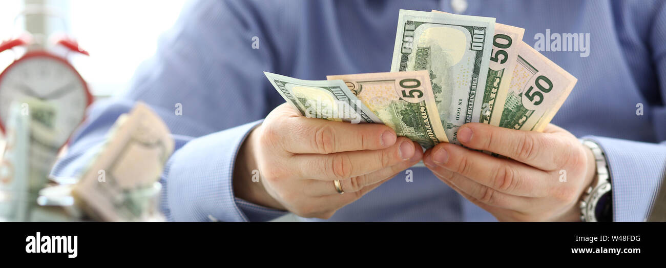 Male arms counting big amount of US currency at worktable Stock Photo ...