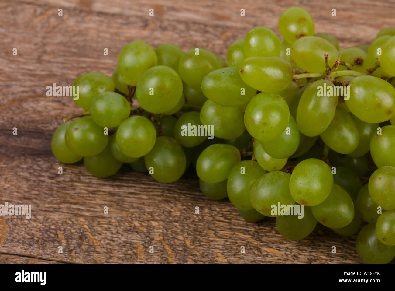 Sweet green grape branch over background Stock Photo - Alamy