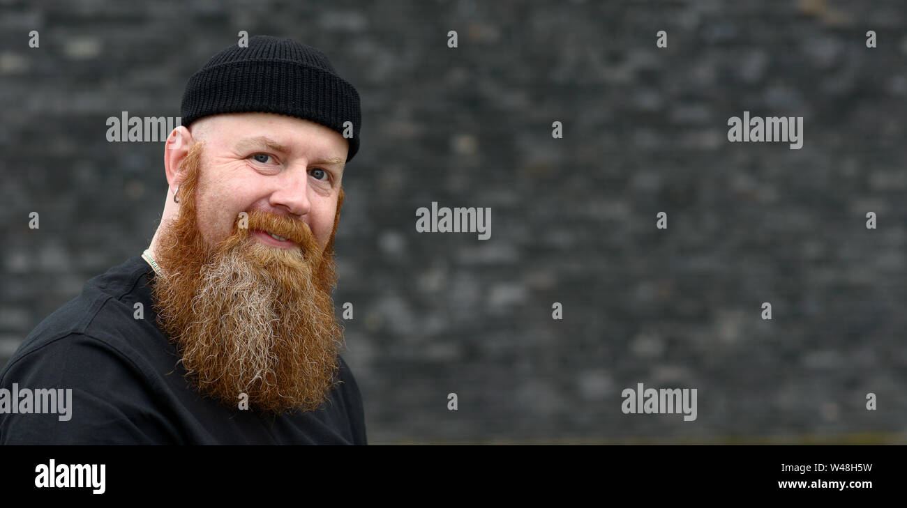 Happy Redhead Man With Bushy Beard And Blue Eyes Wearing A Beanie Hat