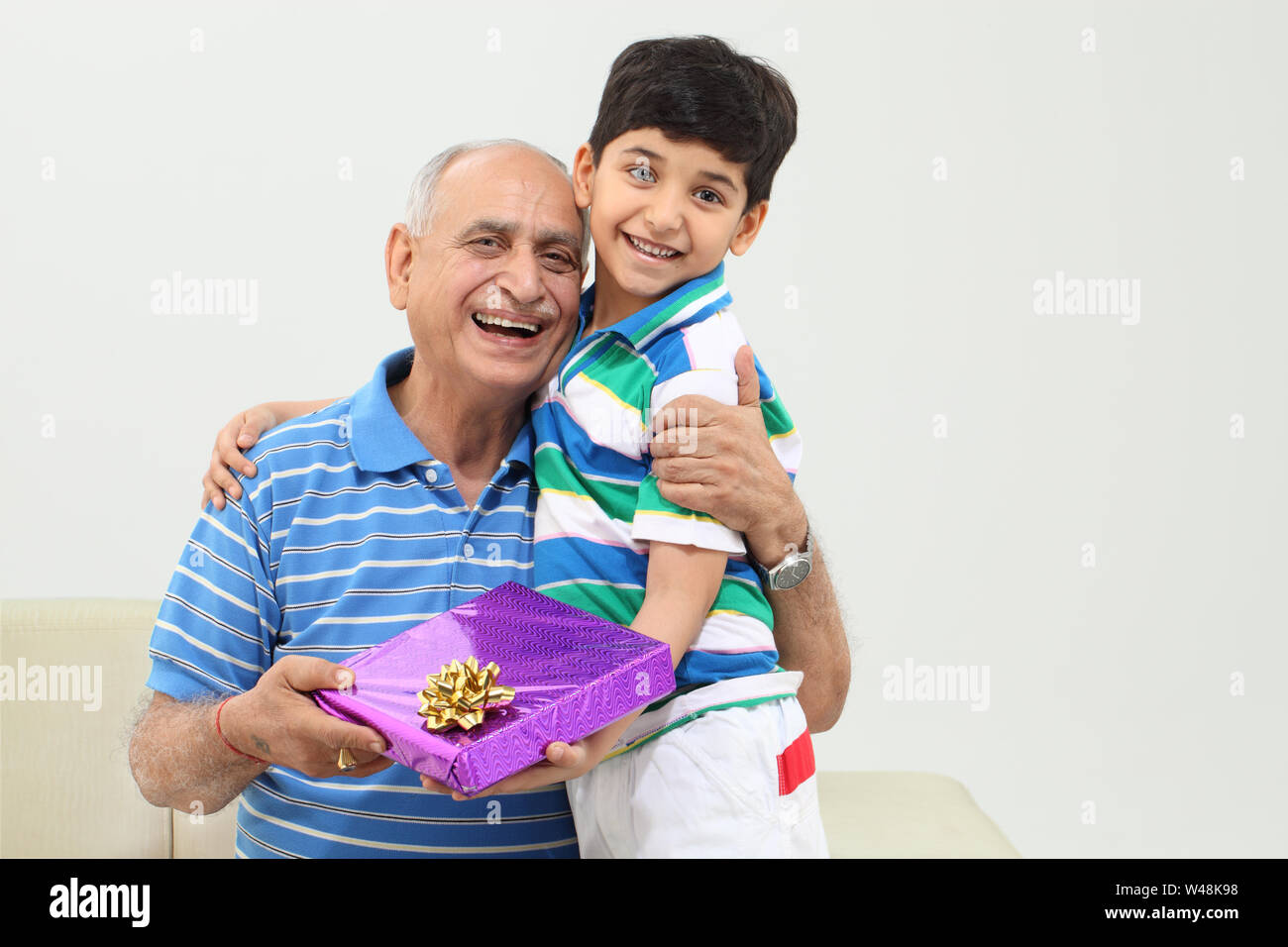 Boy receiving gift from her grandfather Stock Photo - Alamy
