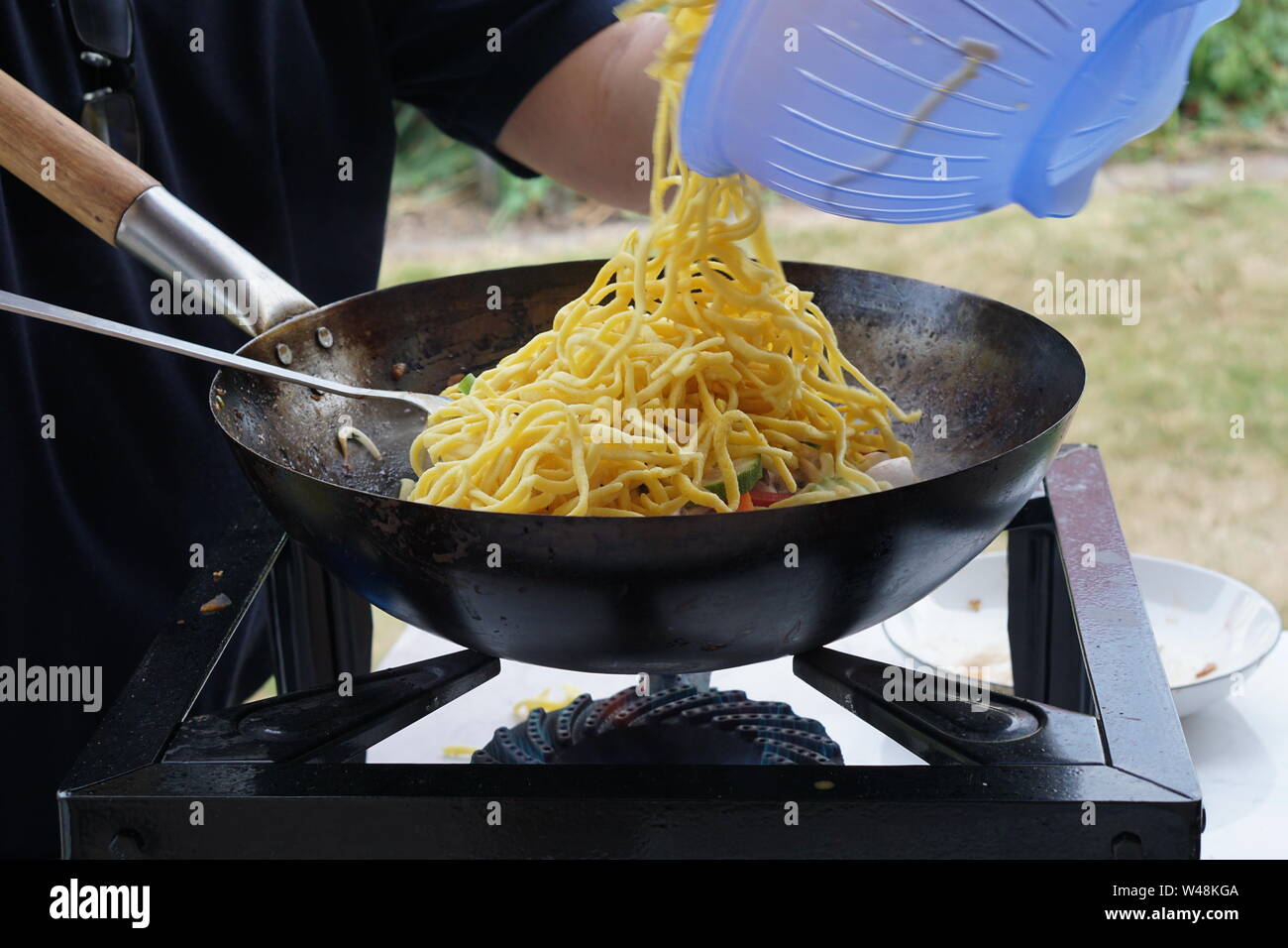 Cooking asian food in a wok pan Stock Photo - Alamy