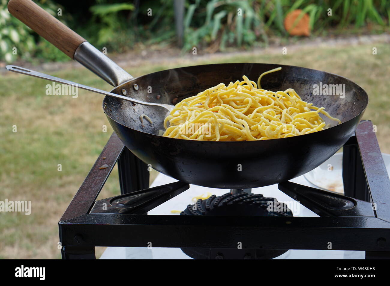 Cooking asian food in a wok pan Stock Photo - Alamy