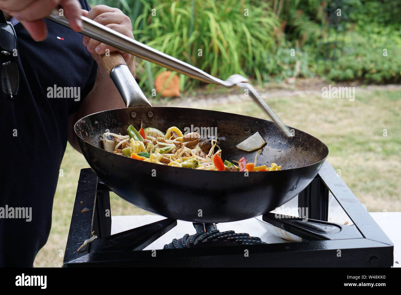 Cooking asian food in a wok pan Stock Photo - Alamy