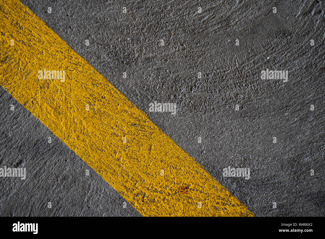 Concrete texture with a yellow painted line. Background graphic asset ...