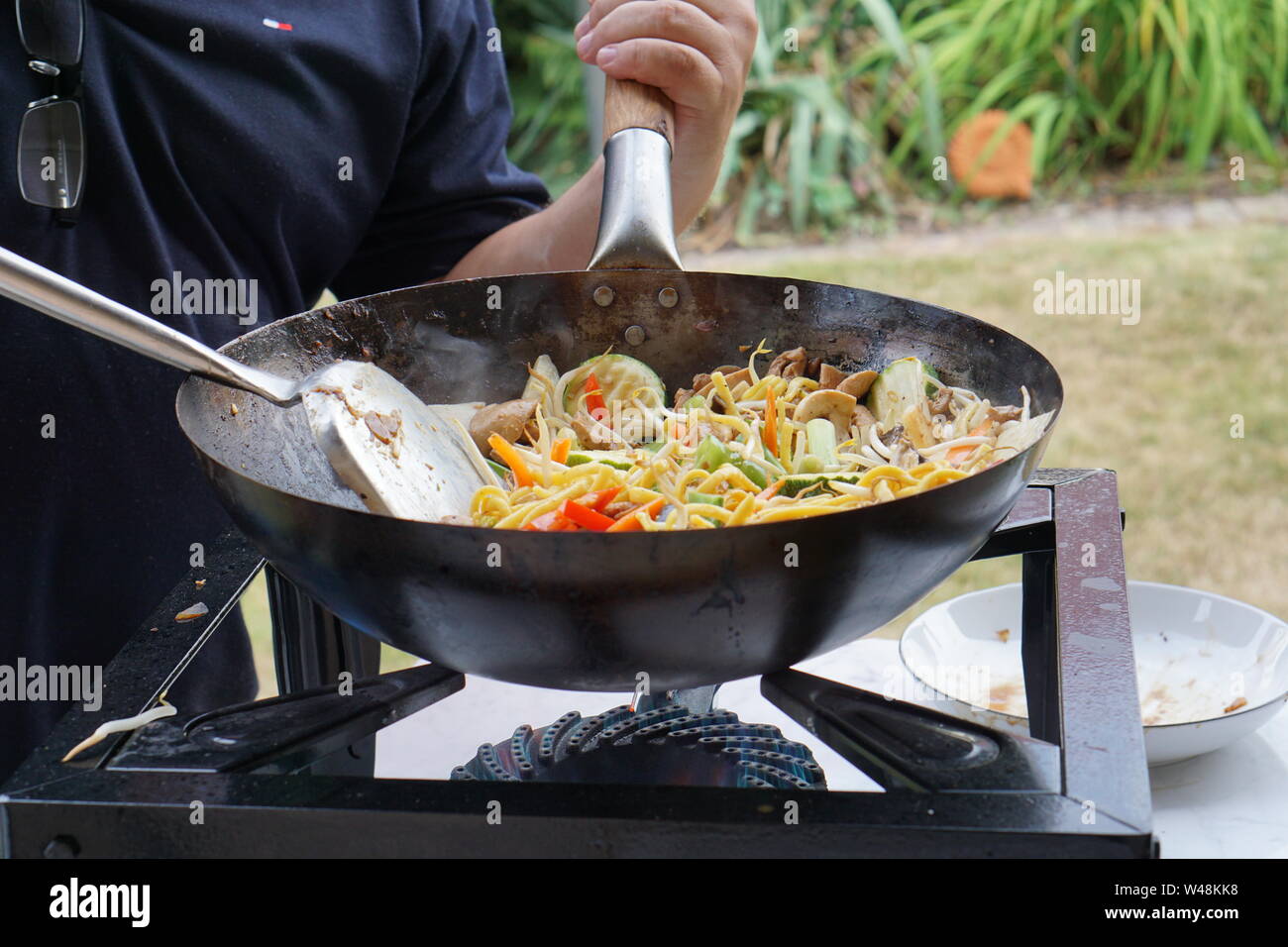 Cooking asian food in a wok pan Stock Photo - Alamy