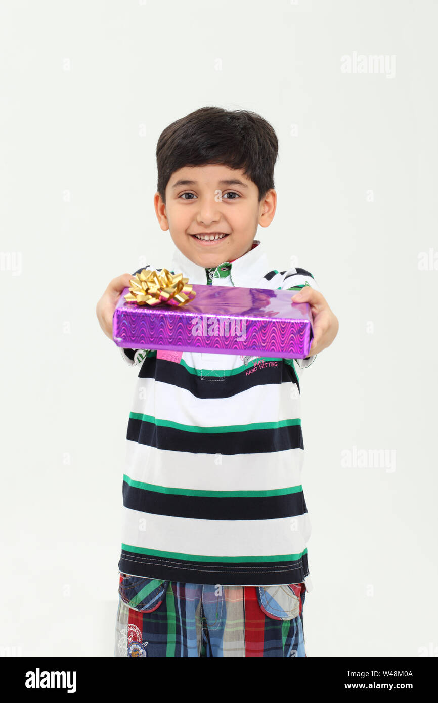 Boy showing gift box and smiling Stock Photo - Alamy