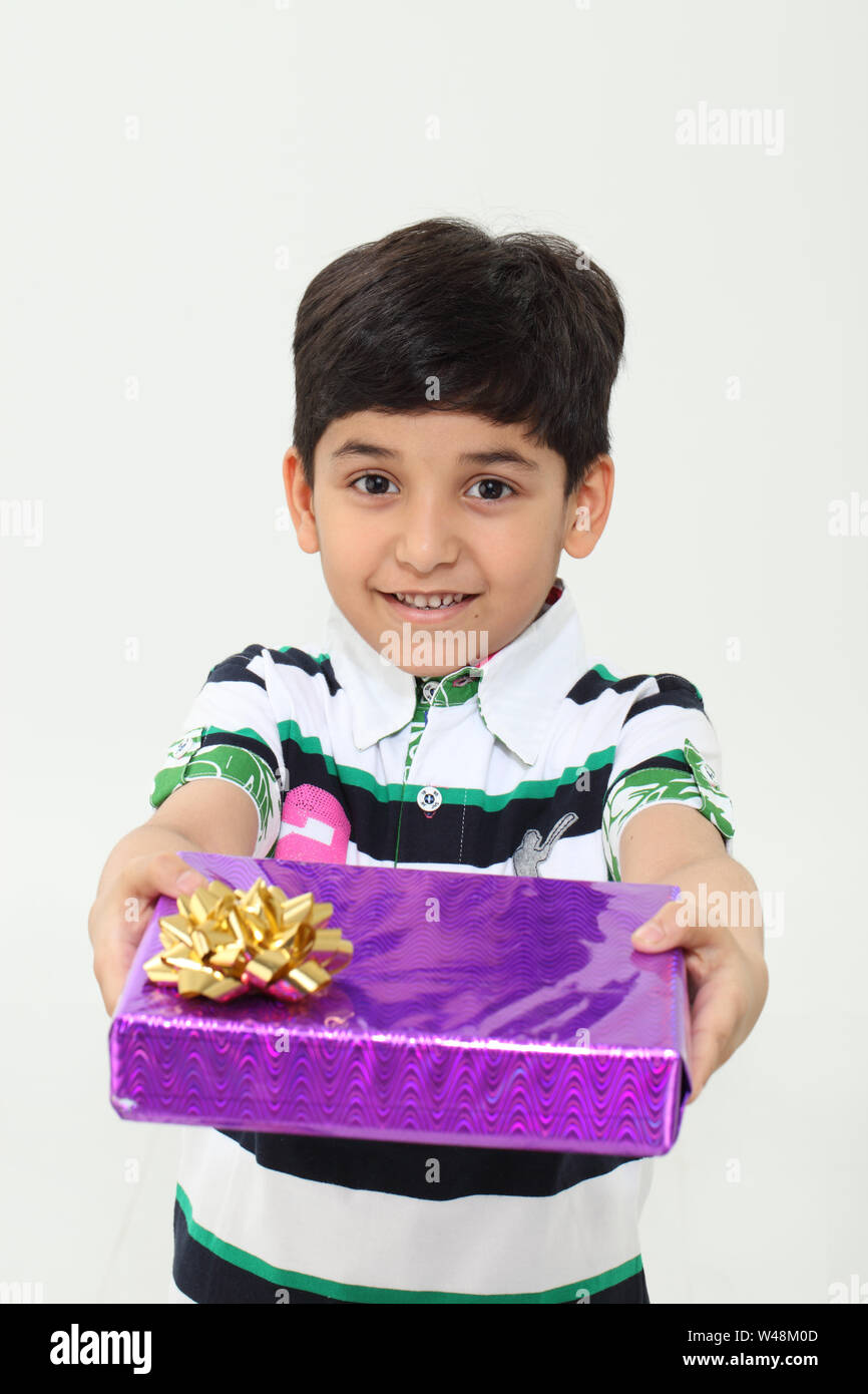 Boy showing gift box and smiling Stock Photo - Alamy