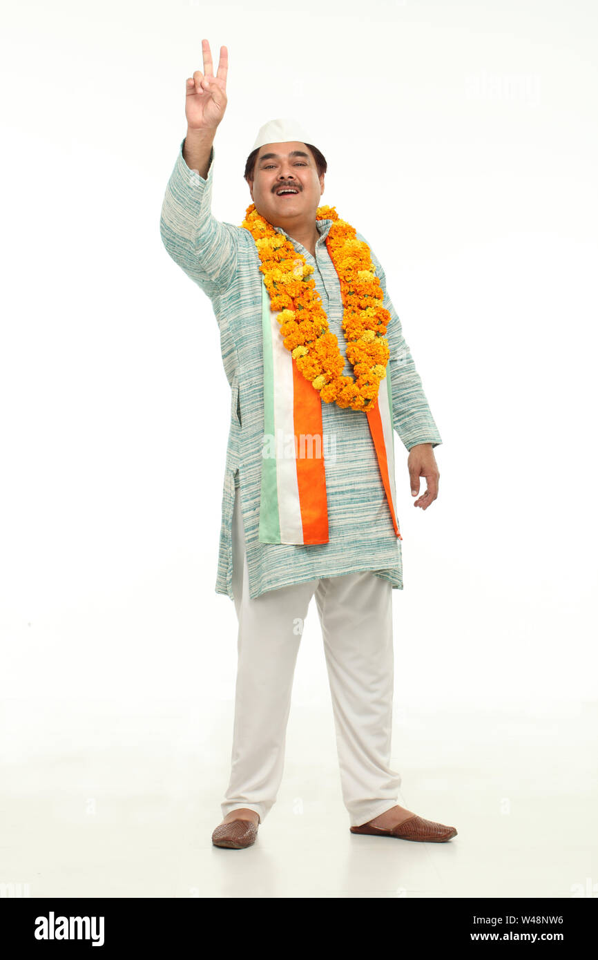 Portrait of a politician showing victory sign and smiling Stock Photo ...