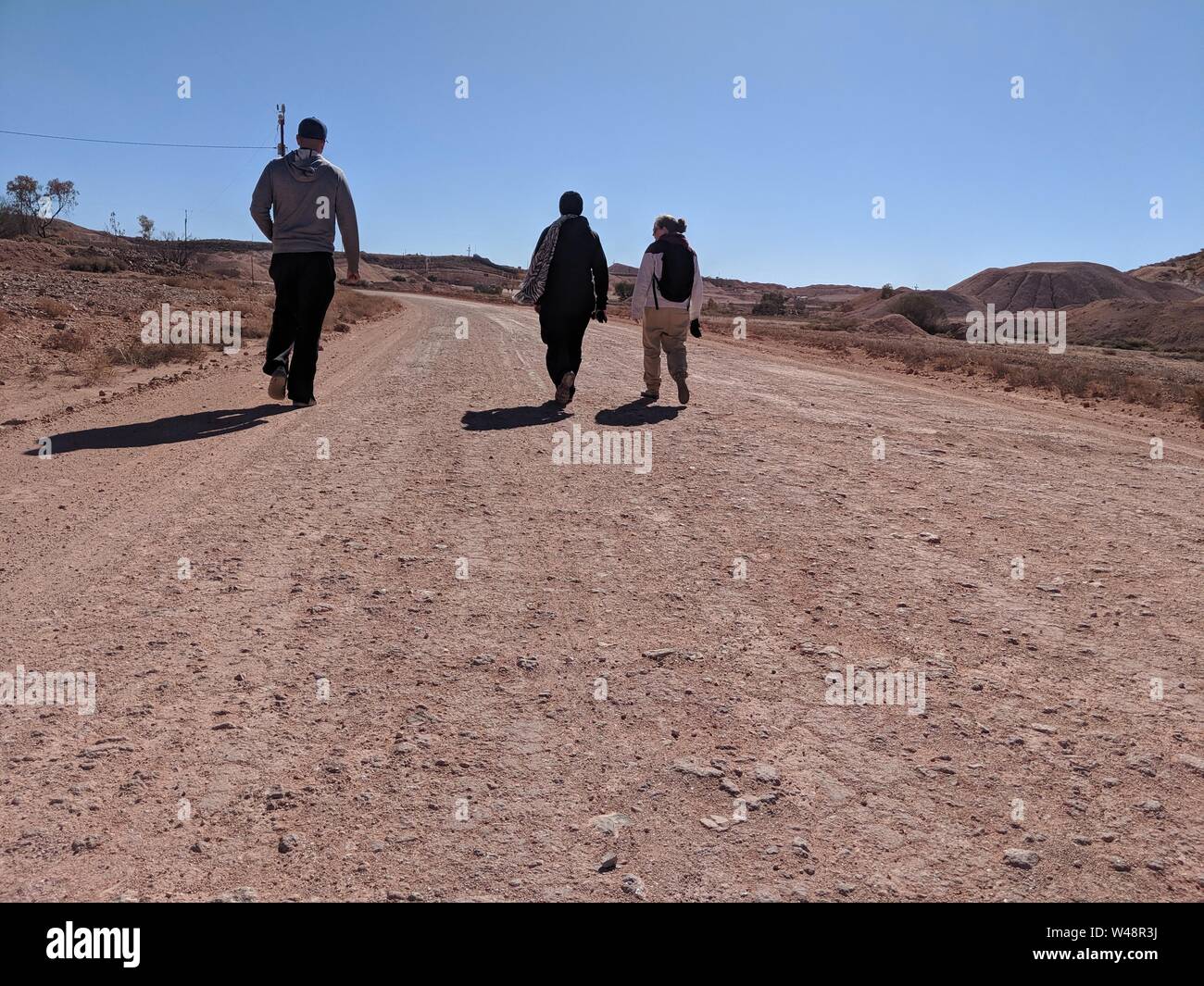 Three people walking in the outback, Coober Pedy, red centre of ...