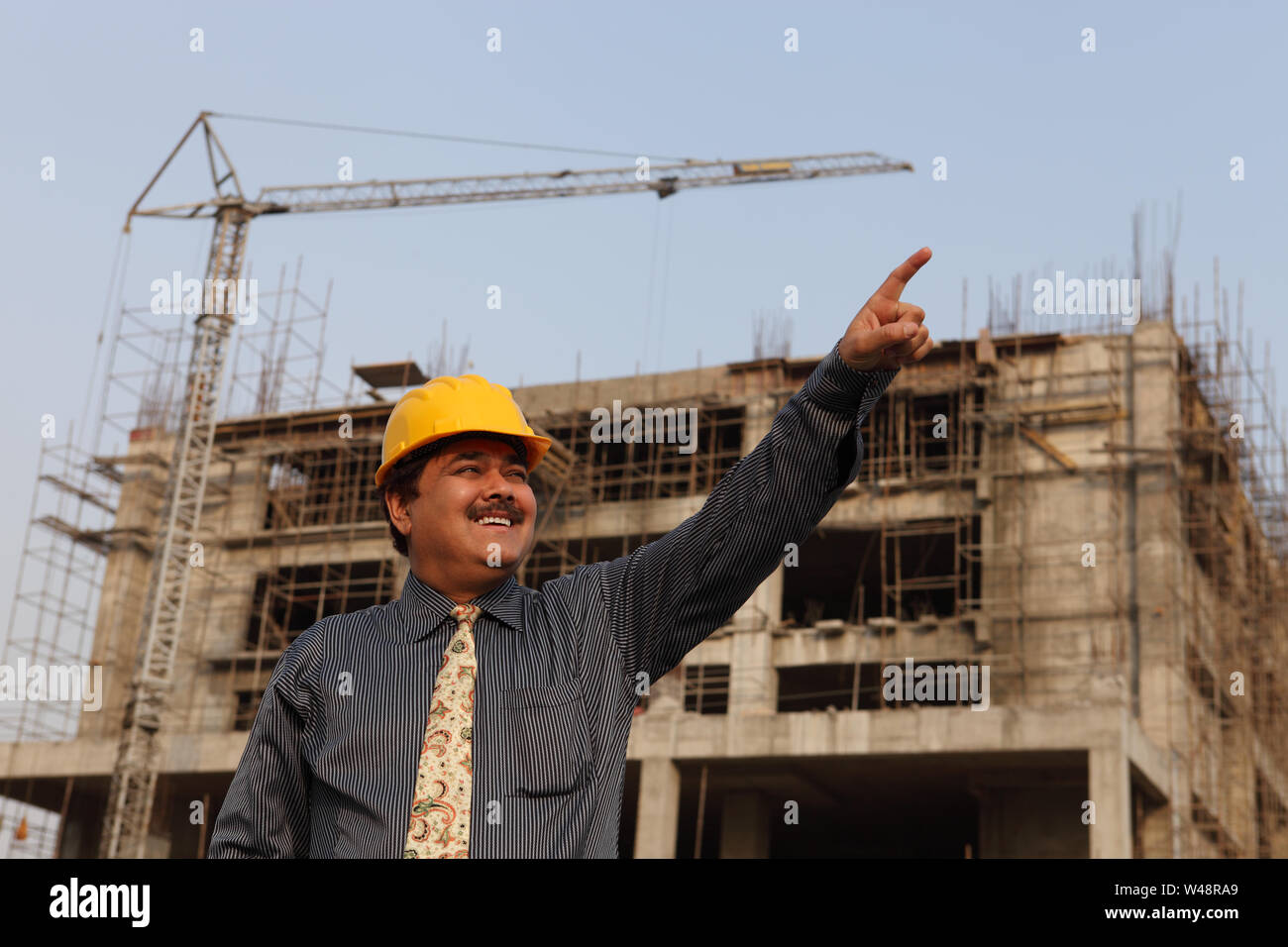 Architect pointing at construction site Stock Photo - Alamy